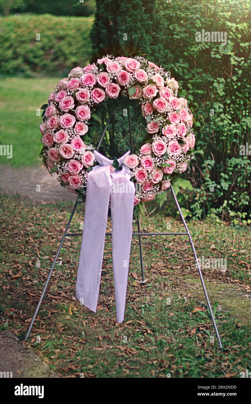 Pink funeral rose wreath on the cemetery Stock Photo - Alamy