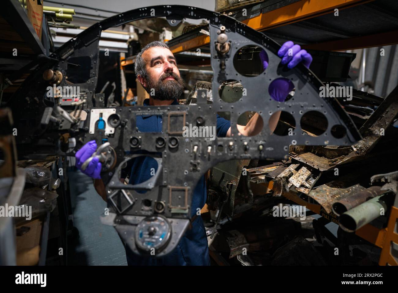 Conservation Engineer Will Gibbs inspects a cockpit instrument panel ...