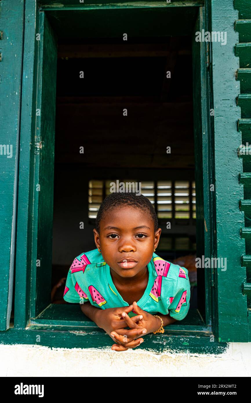 Young school kids looking out from a window, Ciudad de la Paz, Rio Muni ...