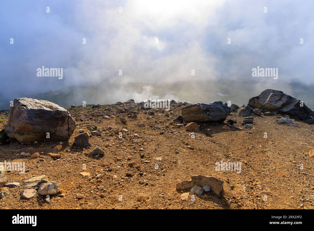 Mist and fog rises over rocky summit of volcanic mountain Stock Photo ...