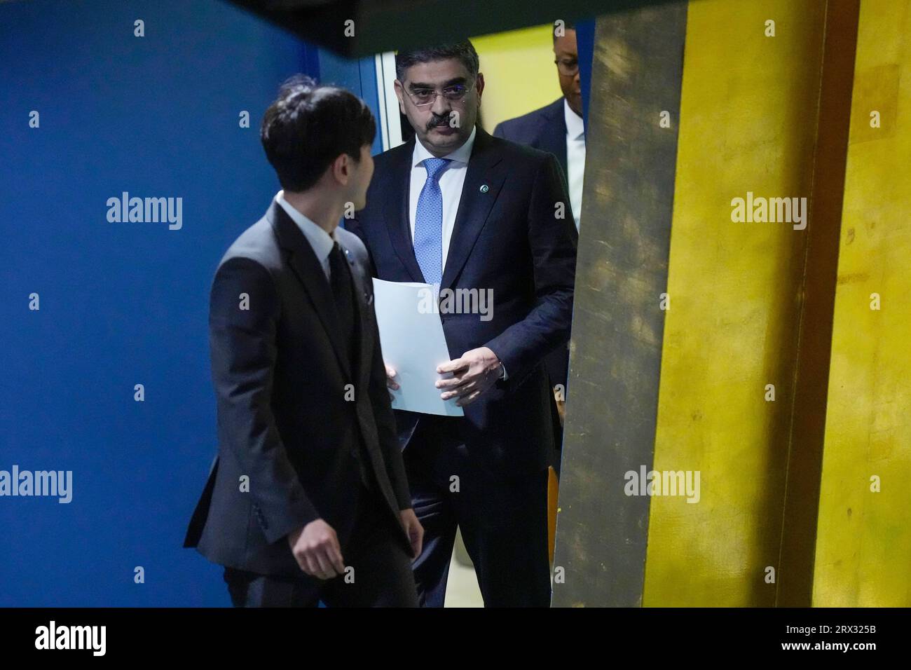 Pakistani Prime Minister Anwaar-ul-Haq Kakar is escorted to the podium ...