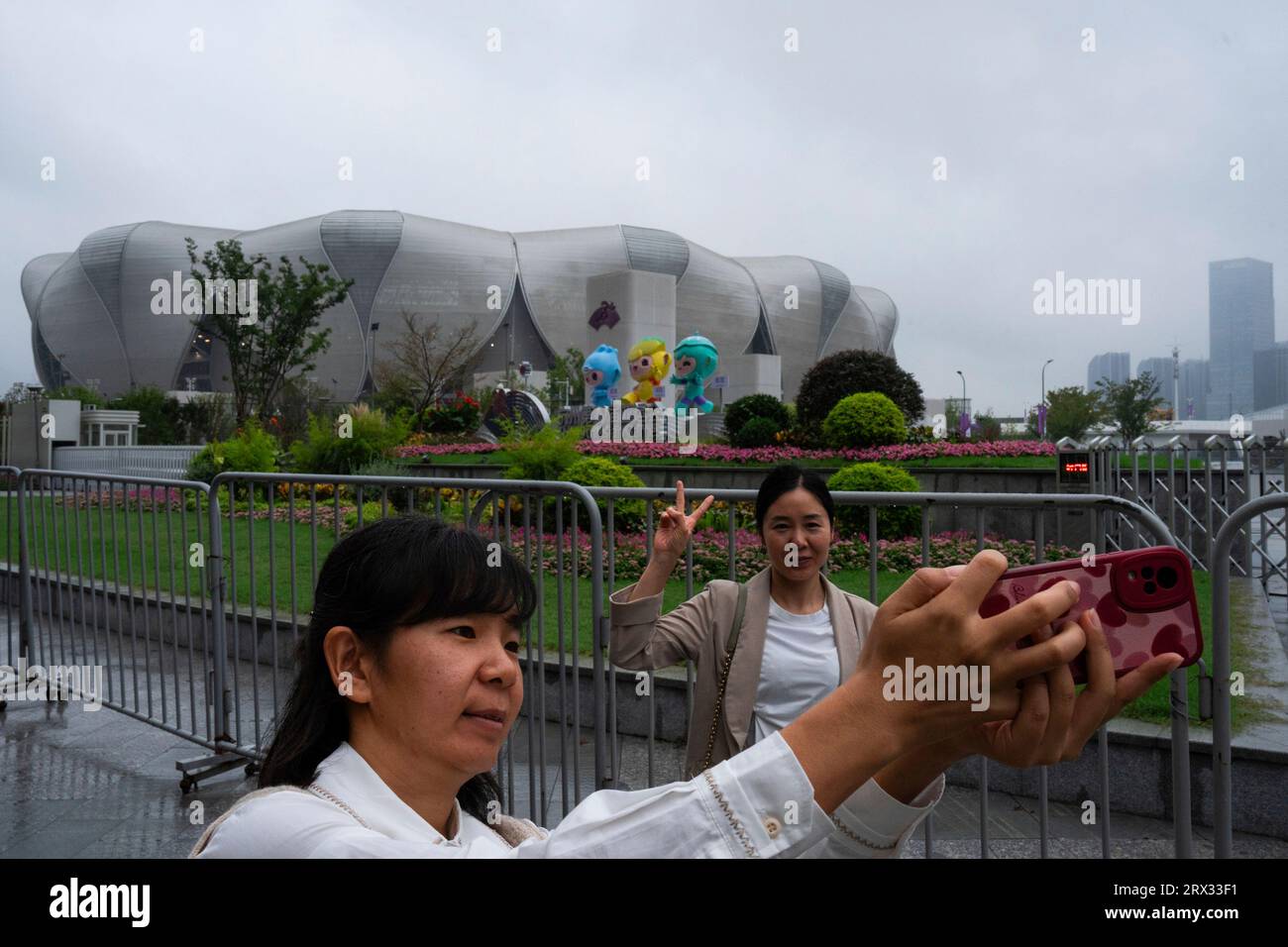 Members of the public take photographs with official mascots of the ...