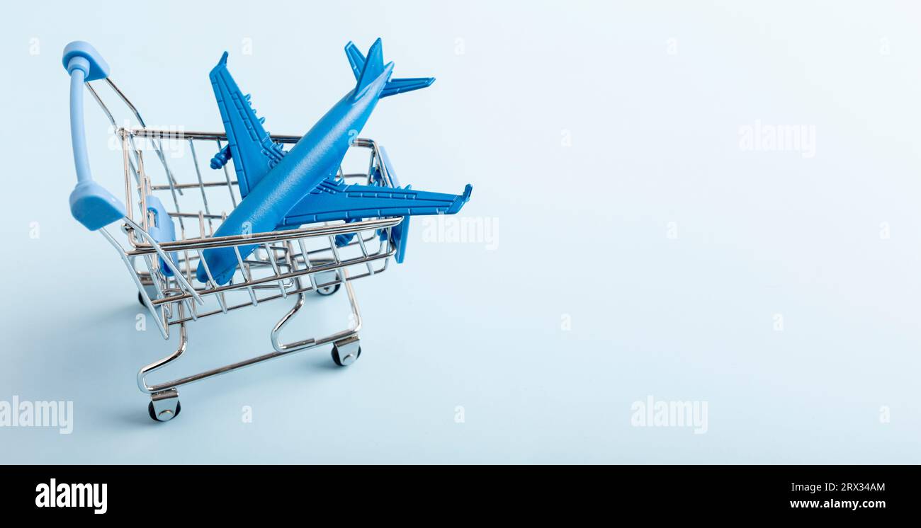 Plane in a shopping trolley. Season travel concept background, toned ...