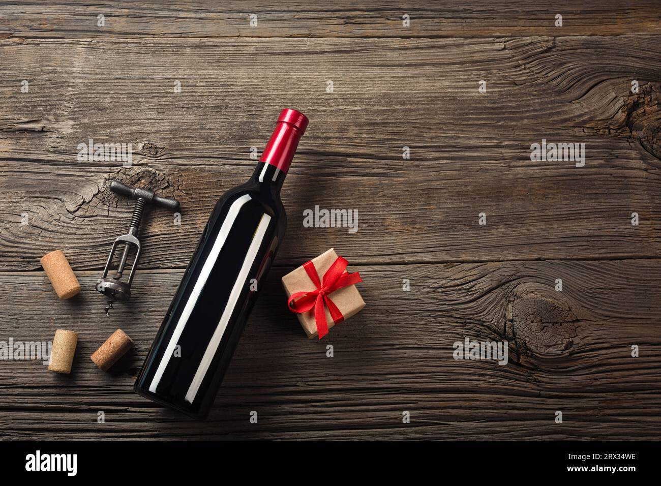 Holiday Dinner setting with red wine and gift on rustic wood in flat ...