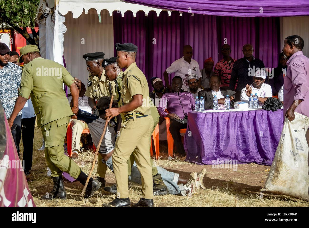 Police officers arresting a man at ACT Wazalendo party's political ...