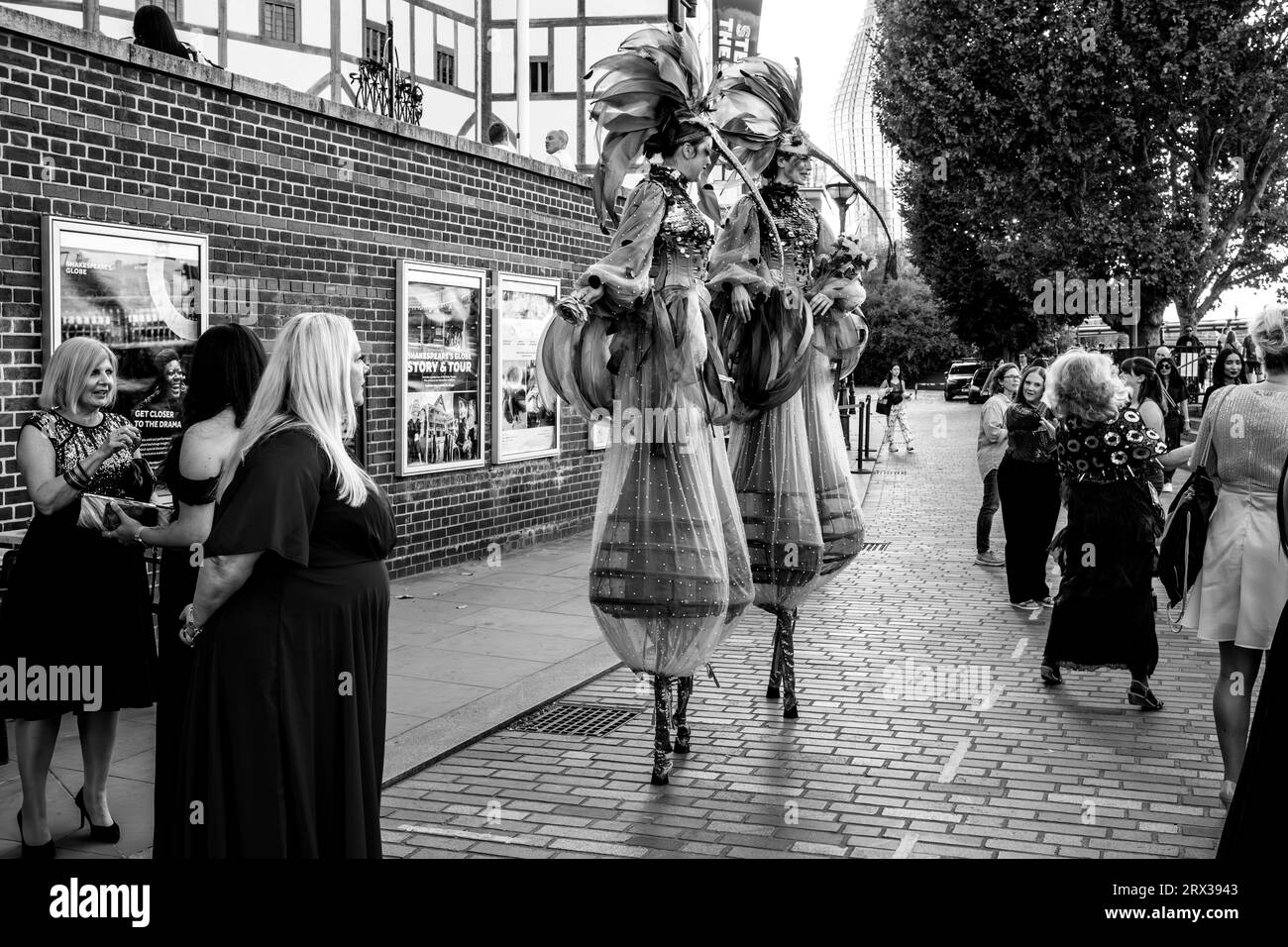 Two Women on Stilts Entertain People Outside The Shakespeare's ...