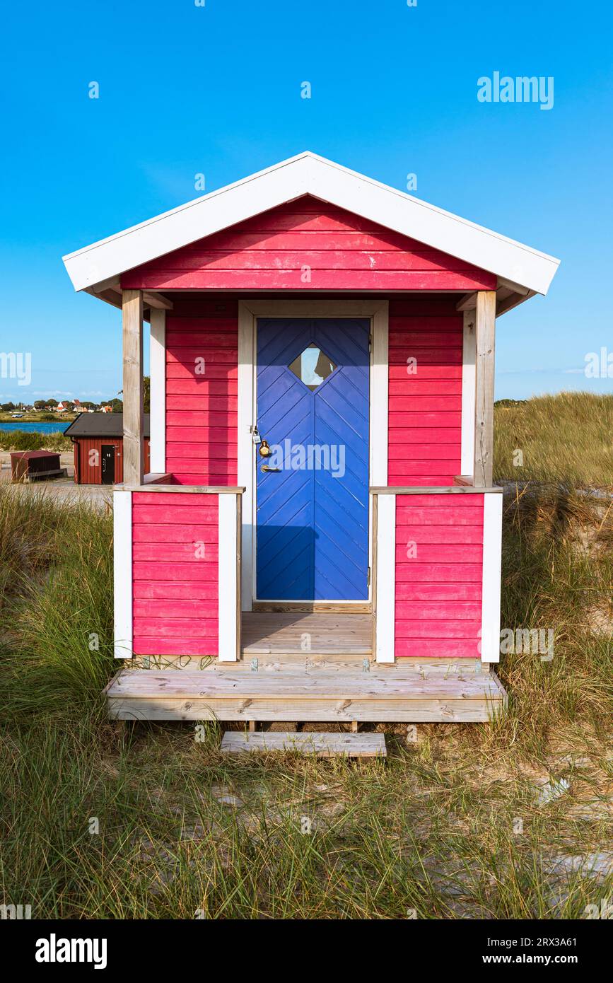 Frontal view of the wooden front of a red bathing hut on the beach of ...