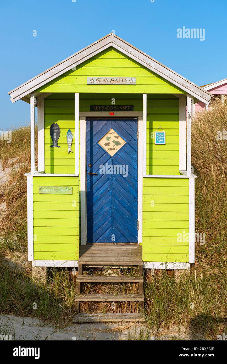 Frontal view of the wooden front of a green bathing hut on the beach of ...