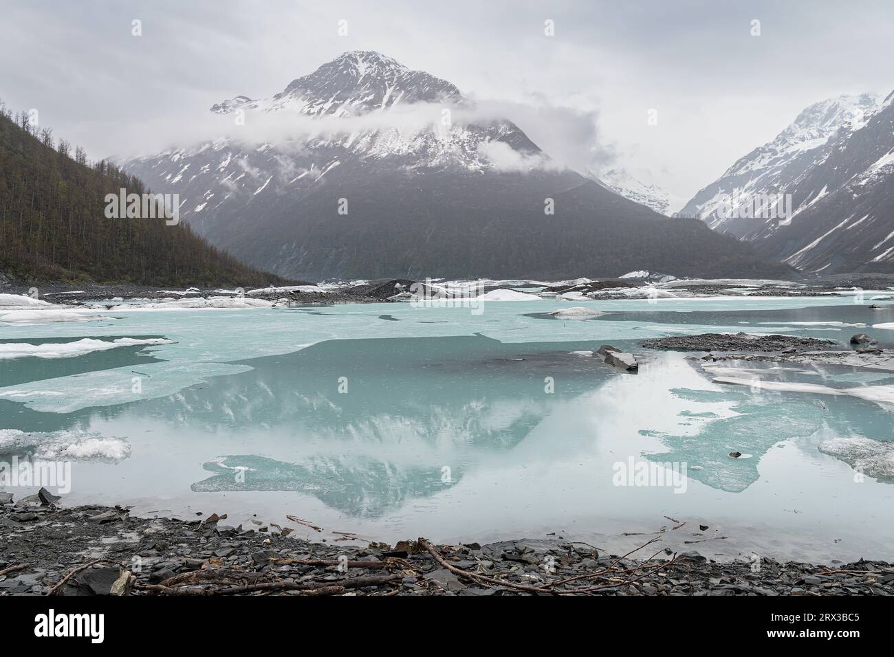 Snow covered mountains reflected between the ice sheets in Valdez ...