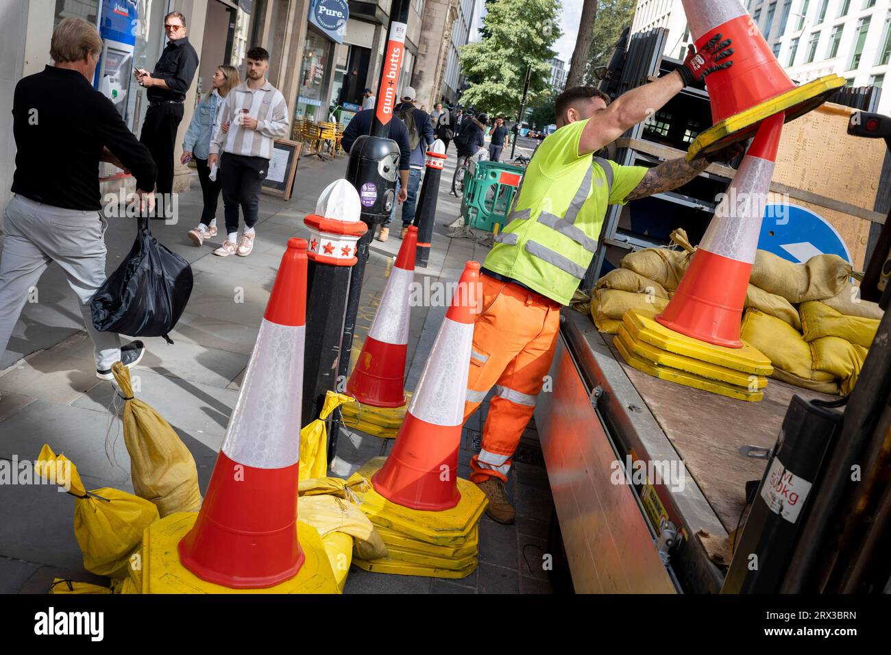 After temporary roadworks, a contractor sorts and stacks road signs and ...