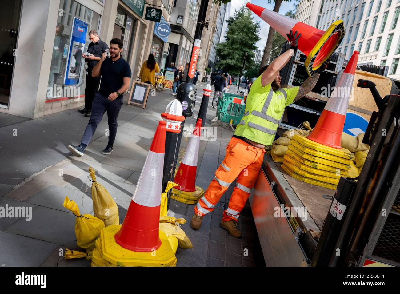 After temporary roadworks, a contractor sorts and stacks road signs and ...