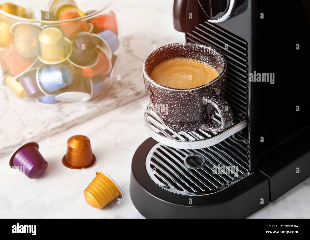 Black coffee cup and home espresso machine with coffee capsules with ...