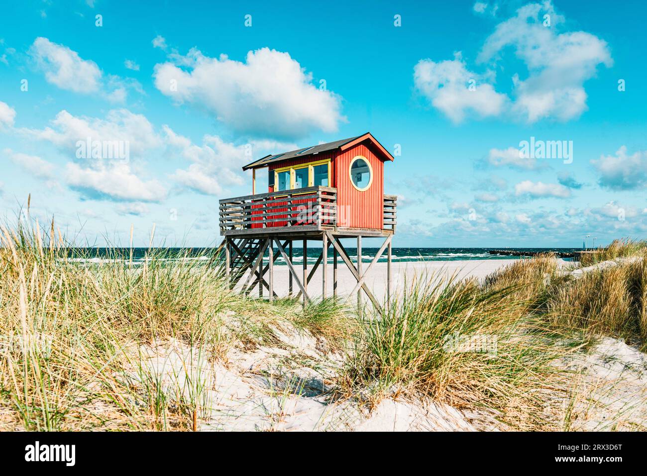 Red wooden lifeguard observation tower on stilts at the beach bar in ...
