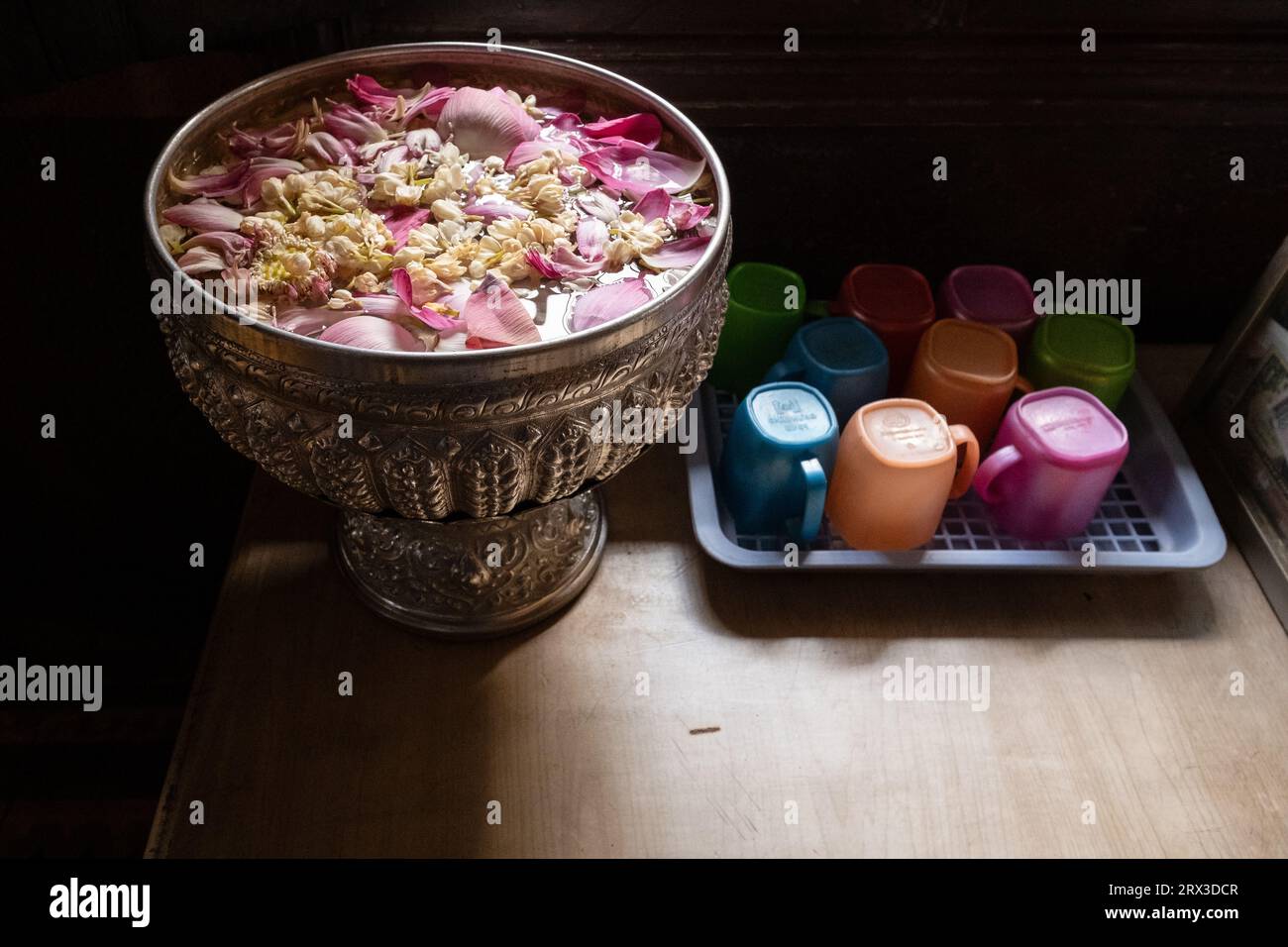 Ornate silver bowl with pink and white petals floating on water, inside ...