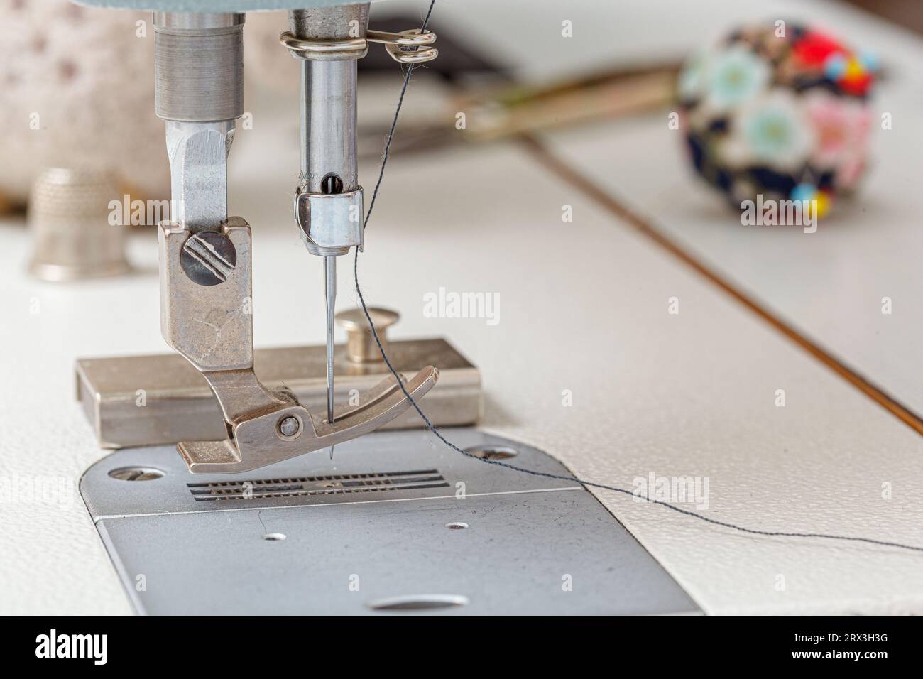 Sewing machine needle with thread and fabric close-up Stock Photo - Alamy