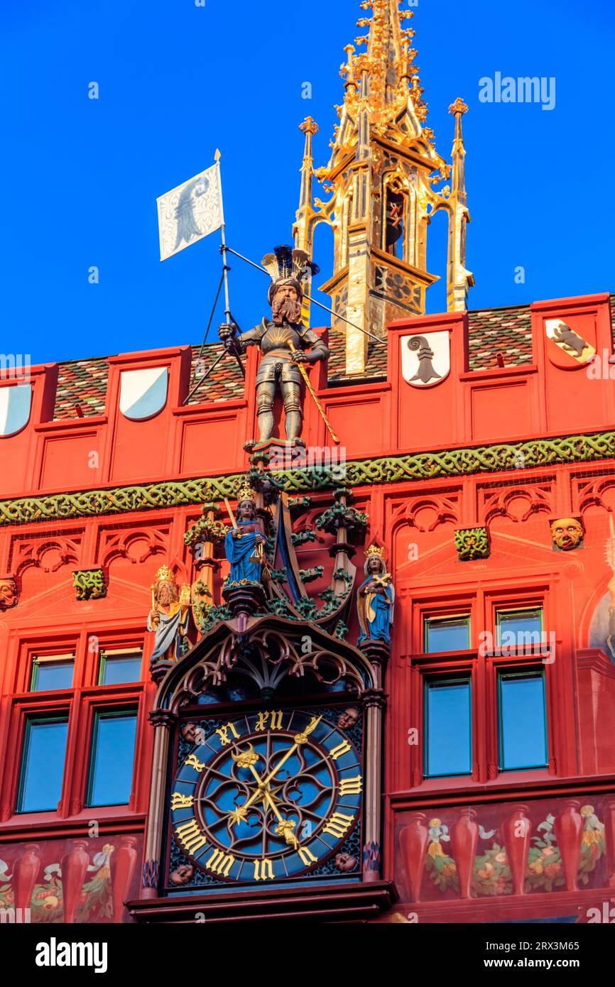 Close-up of red town hall with clock, paintings and ornaments in Basel ...