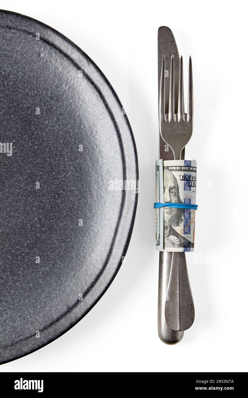 Gray ceramic plate and fork with knife wrapped in hundred dollar bills ...