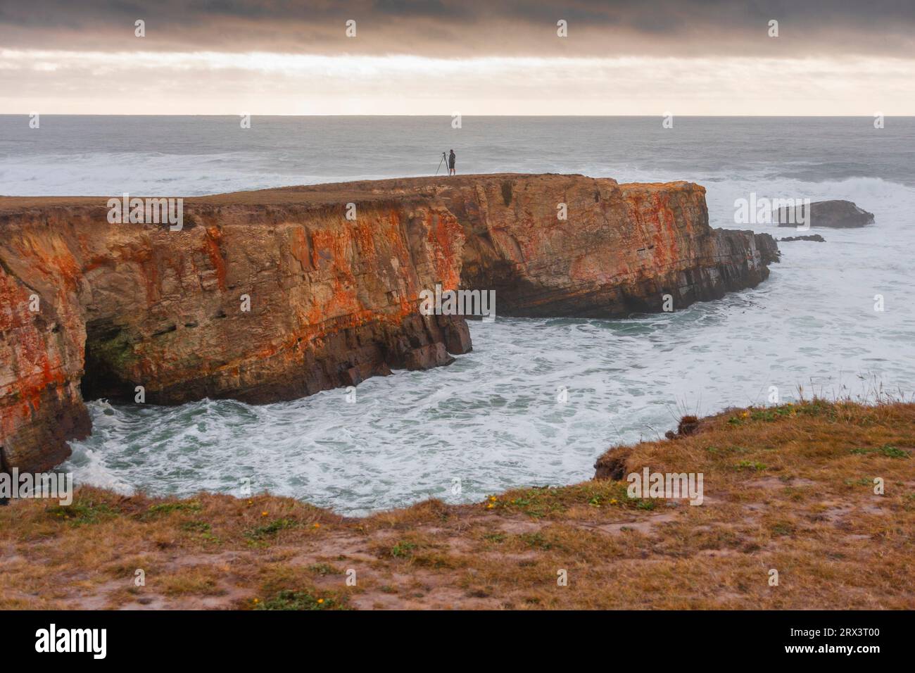 Photographer on cliff at Point Arena on the rocky pacific coast of ...