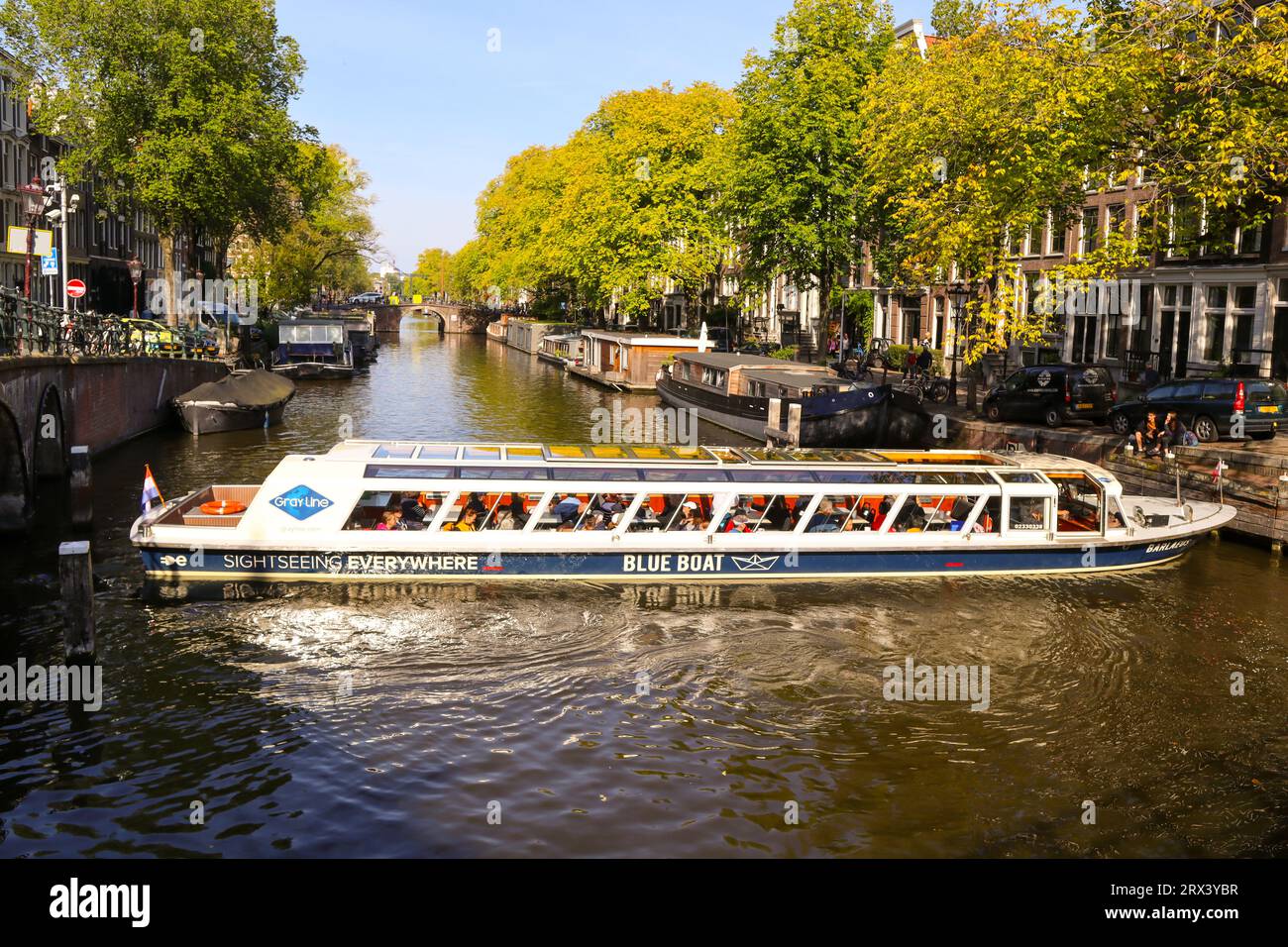 Amsterdam. Amsterdam boat tour canal people. Tourists enjoy riding boat ...