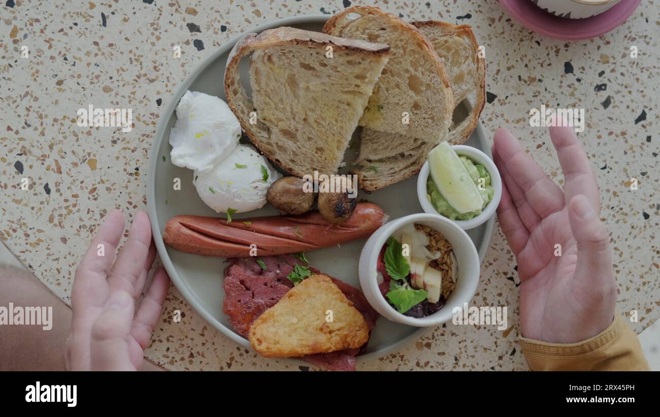 Traditional British breakfast in a plate taken by a man. A close shot ...