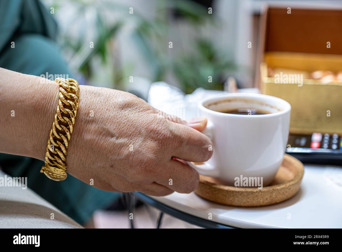 Old lady hand holding white cup of coffee with chocolate pieces have ...