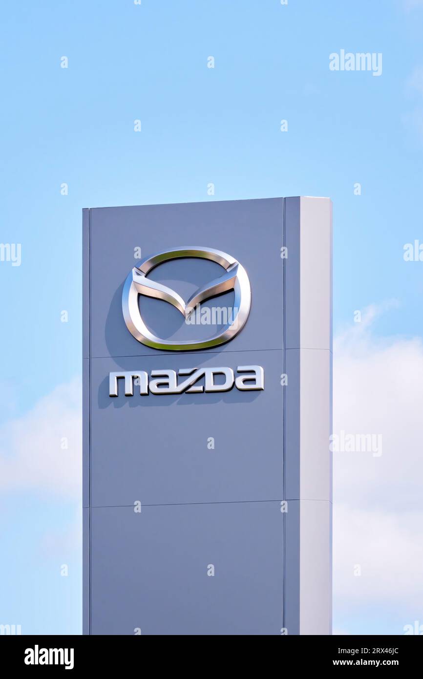 Mazda sign photographed against a blue sky on portrait orientation ...