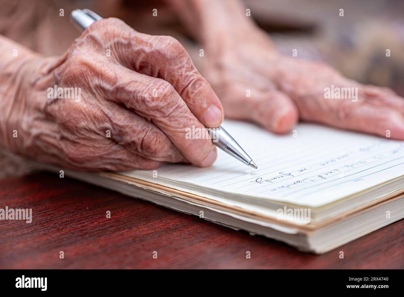 wrinkled hands for elderly person writing notes on his note book Stock ...