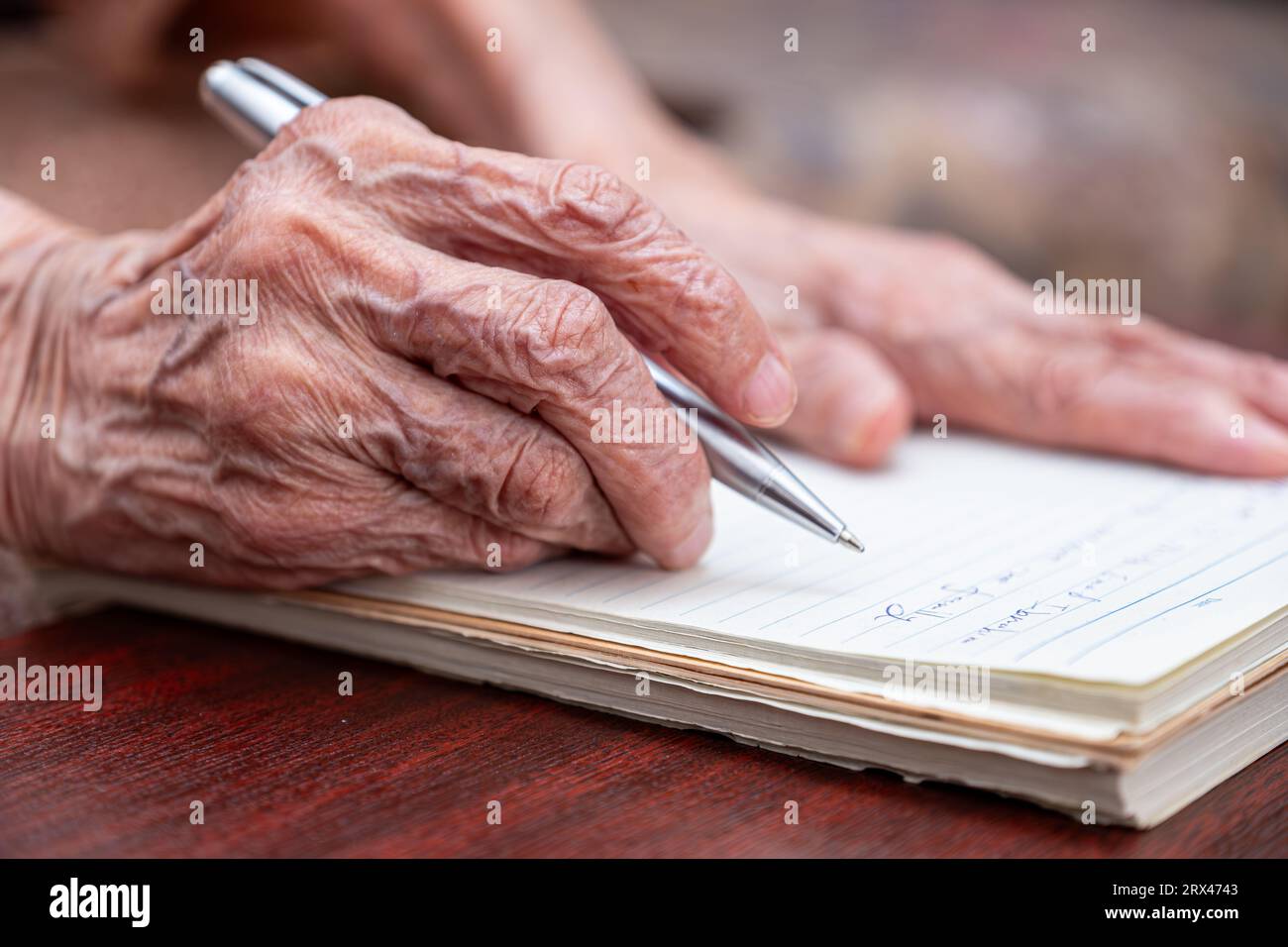 wrinkled hands for elderly person writing notes on his note book Stock ...