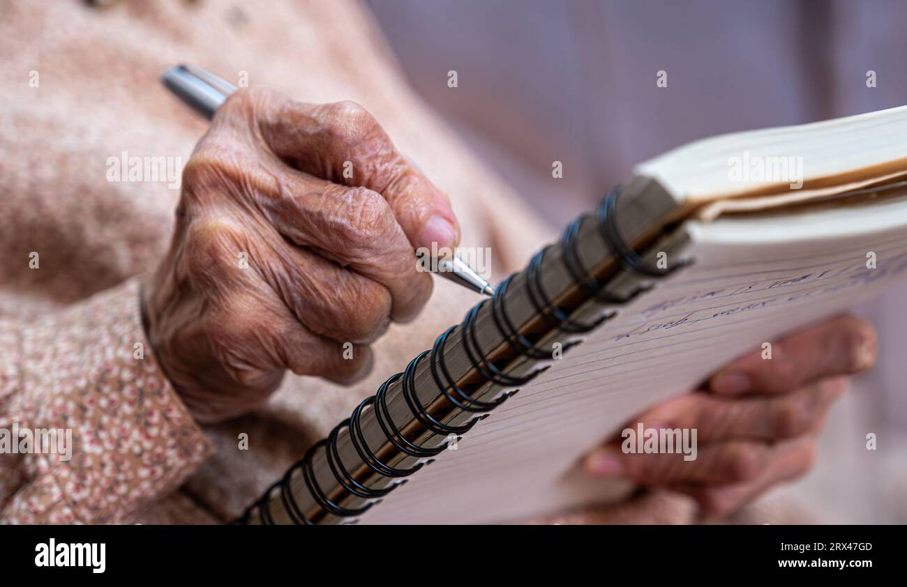 wrinkled hands for elderly person writing notes on his note book Stock ...