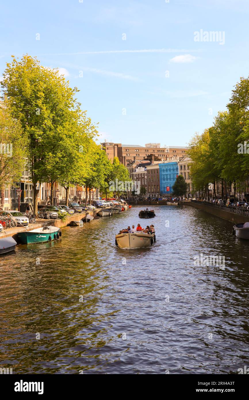 Amsterdam. Amsterdam boat tour canal people. Tourists enjoy riding boat ...