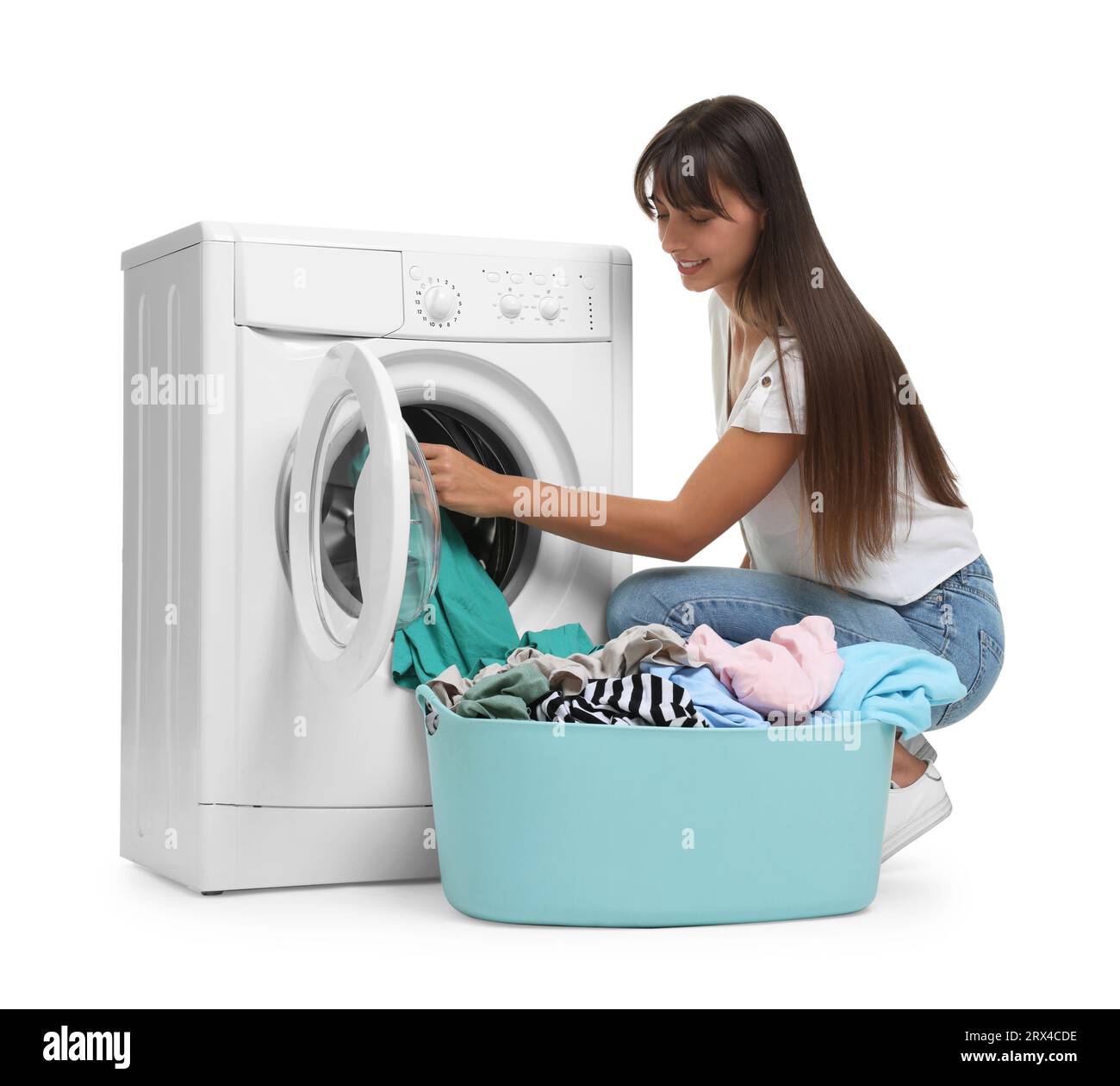 Beautiful woman taking laundry out of washing machine on white ...