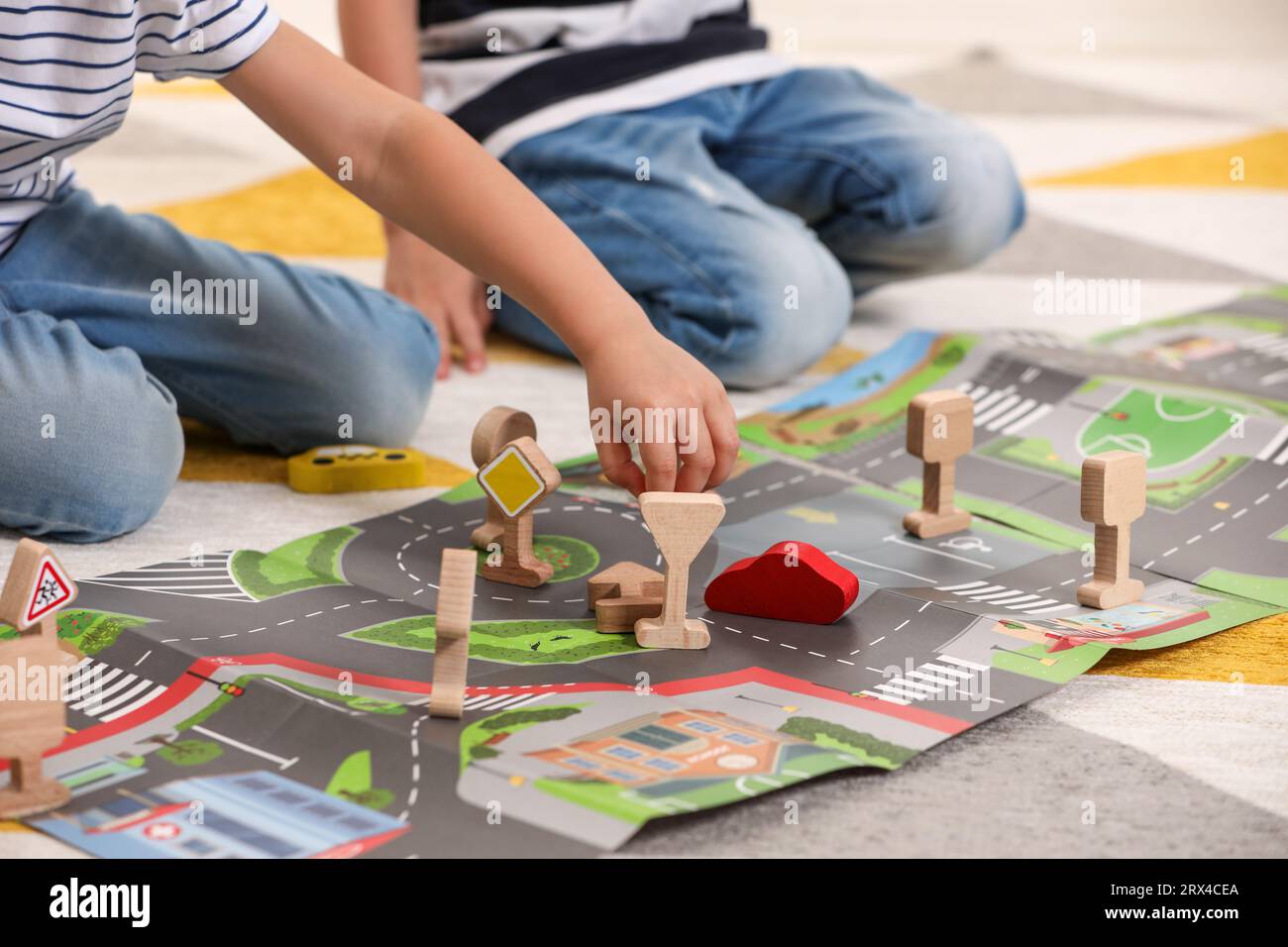 Little children playing with set of wooden road signs and toy cars ...