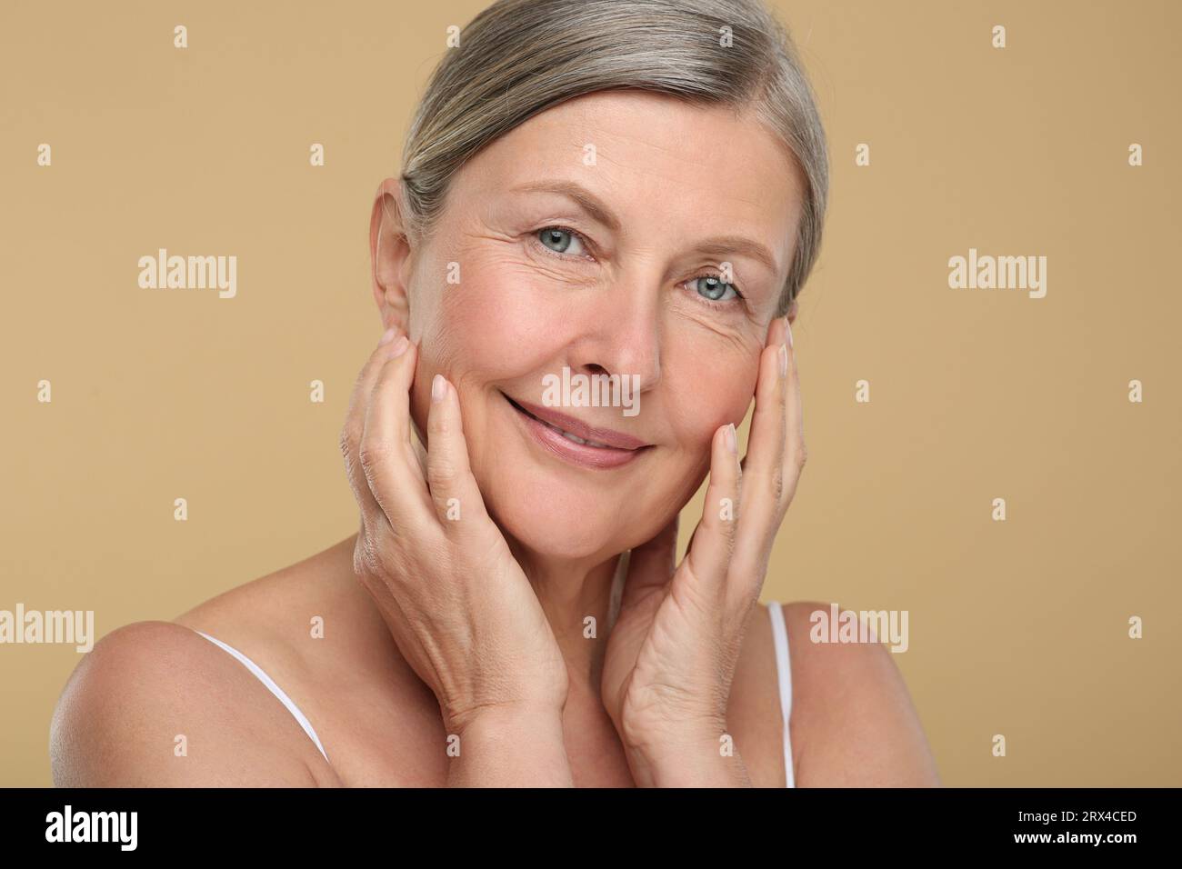 Portrait of senior woman with aging skin on beige background ...