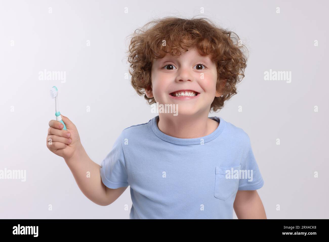 Cute little boy holding plastic toothbrush on white background Stock ...