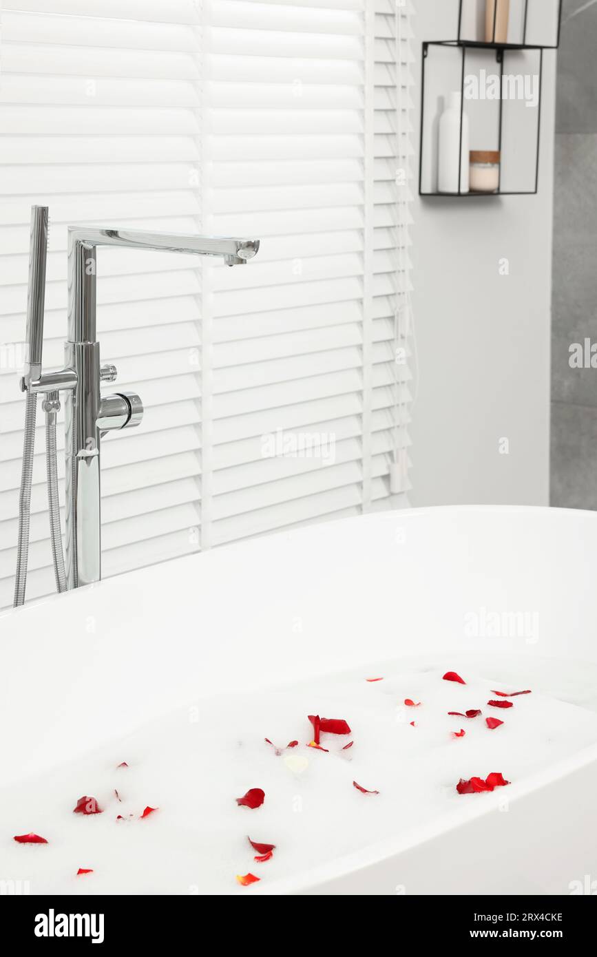 Bath tub with rose petals and foam in bathroom Stock Photo - Alamy