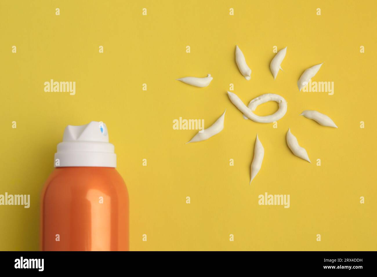 Drawing of sun and bottle with sunscreen on yellow background, top view ...