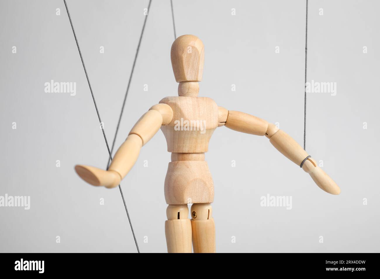 One wooden puppet with strings on light grey background Stock Photo - Alamy