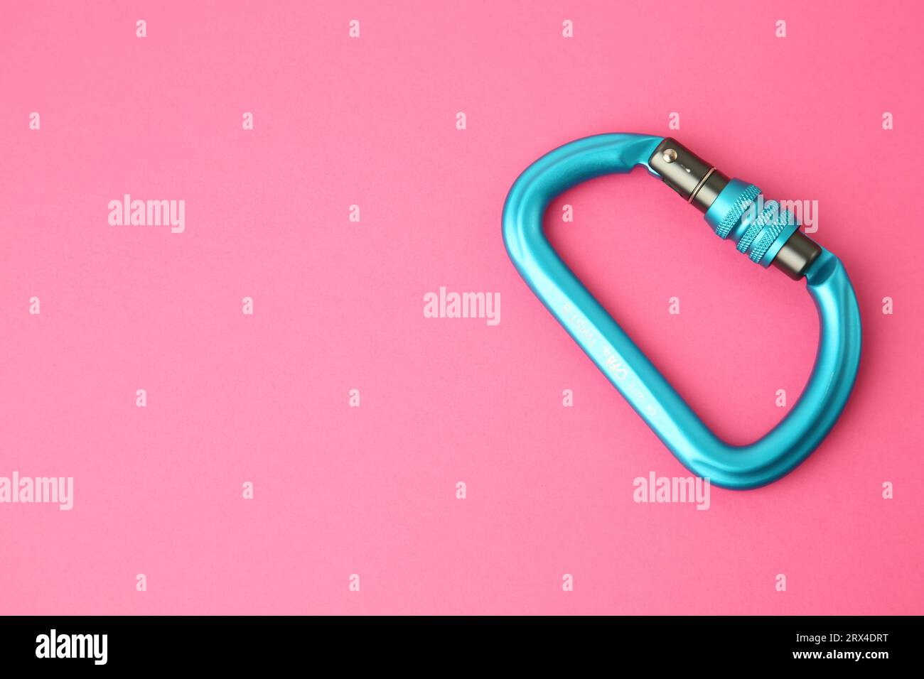 One metal carabiner on bright pink background, top view. Space for text ...