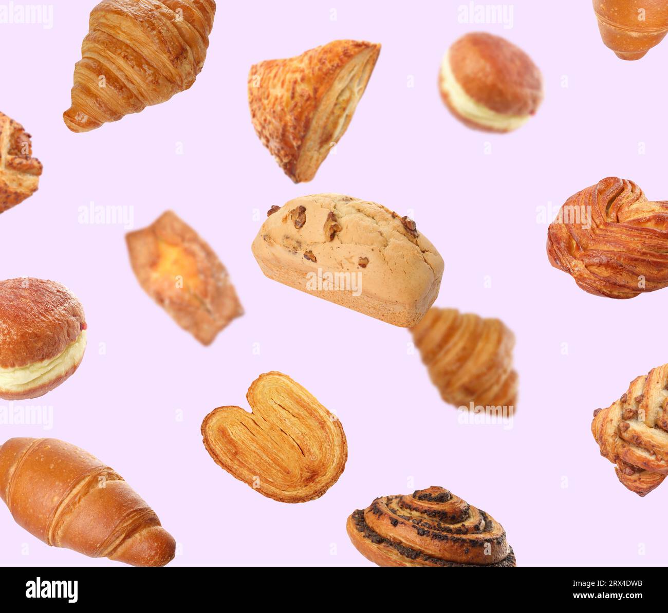 Aromatic fresh pastries falling on pale violet background Stock Photo ...