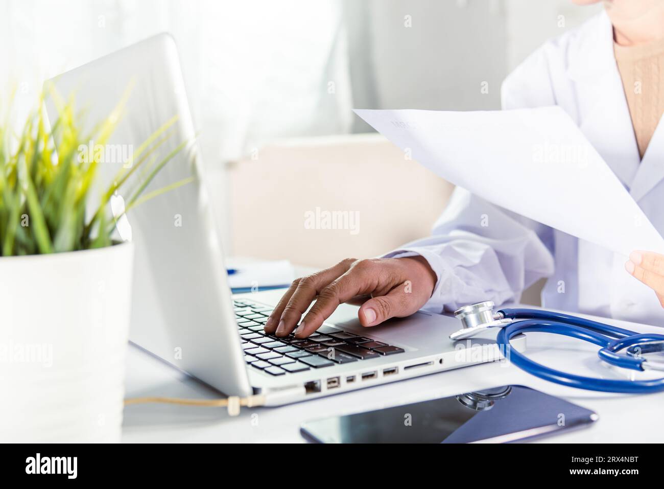 Doctor woman typing information of patient prescription from paperwork ...