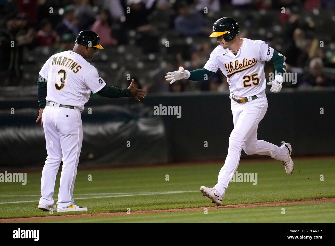 Oakland Athletics' Brent Rooker (25) is congratulated by third base ...