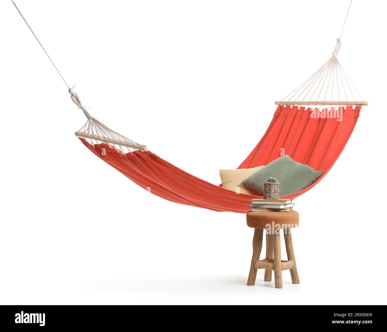 Cozy red hammock with cushions and books with houseplant on soft stool ...