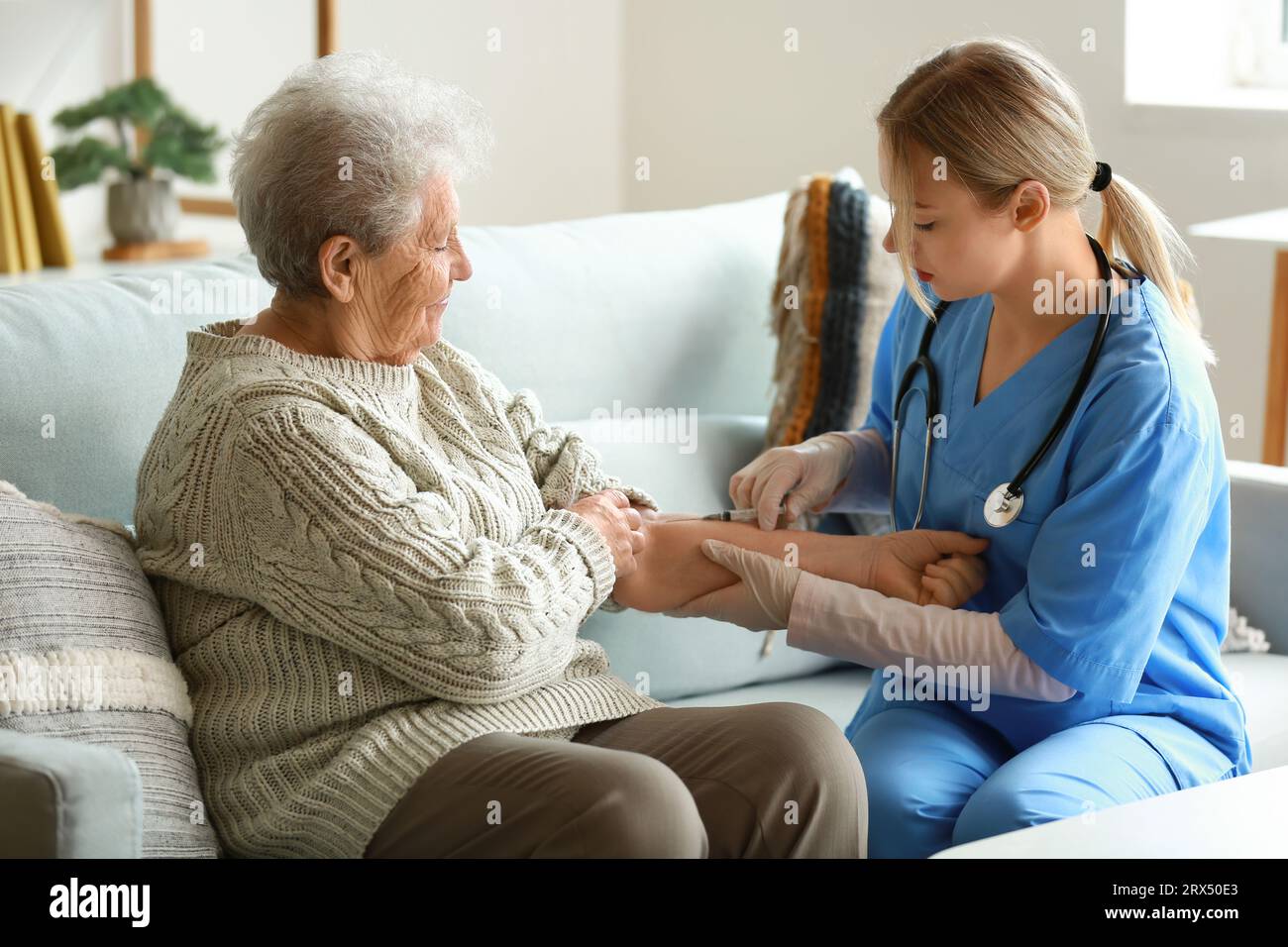 Young caregiver giving senior woman injection at home Stock Photo - Alamy