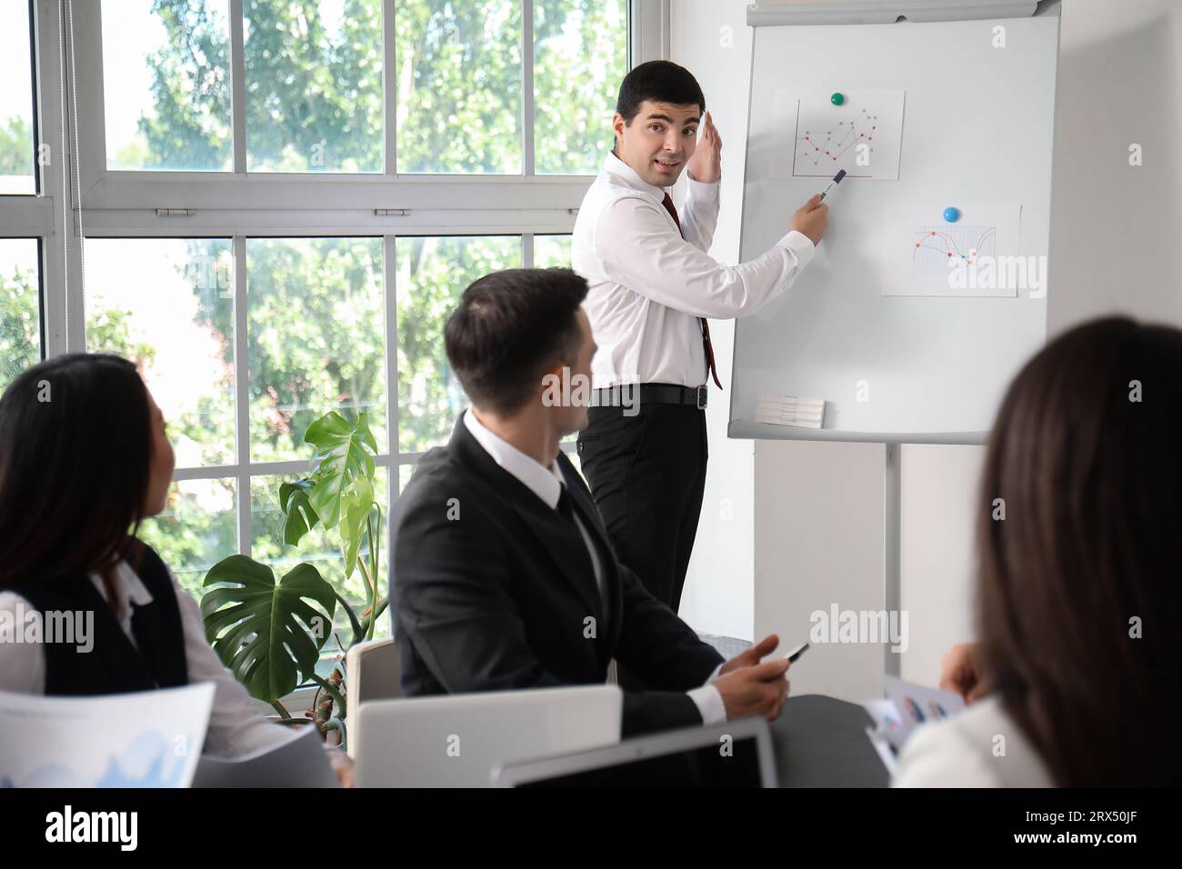 Male business consultant giving presentation to his colleagues in ...