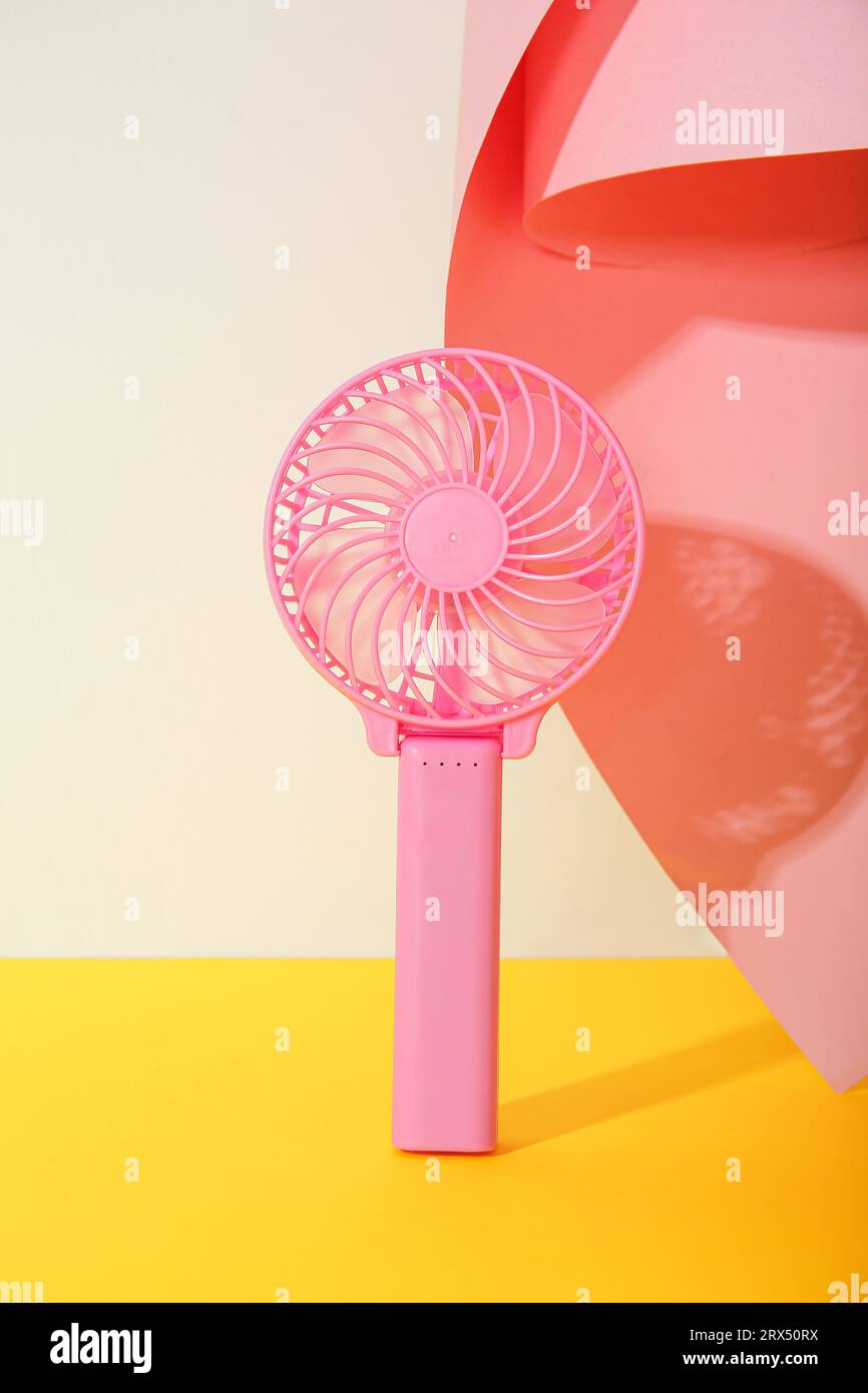Mini pink electric fan on color background Stock Photo - Alamy