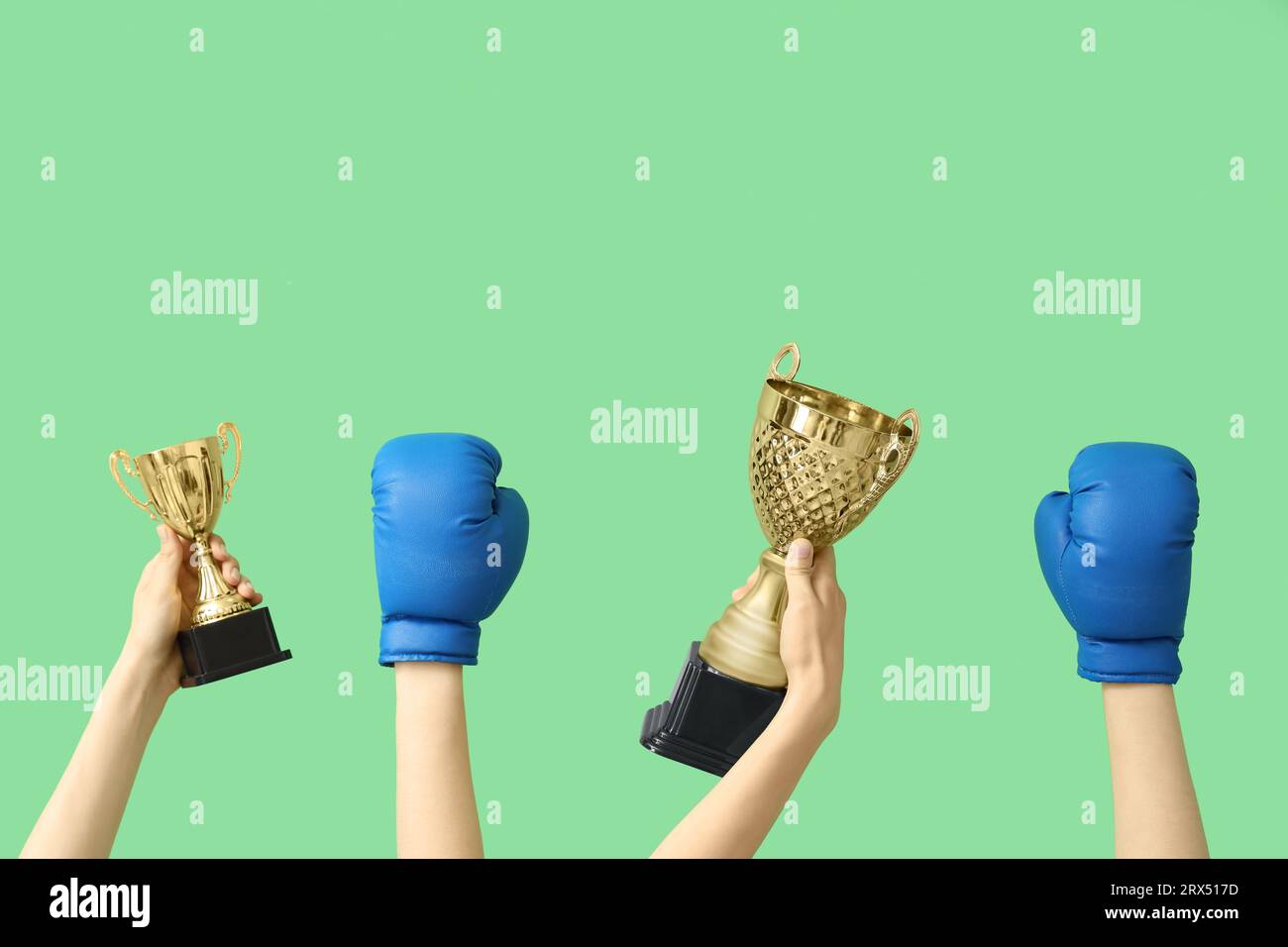 Female hands with gold cups and boxing gloves on green background Stock ...