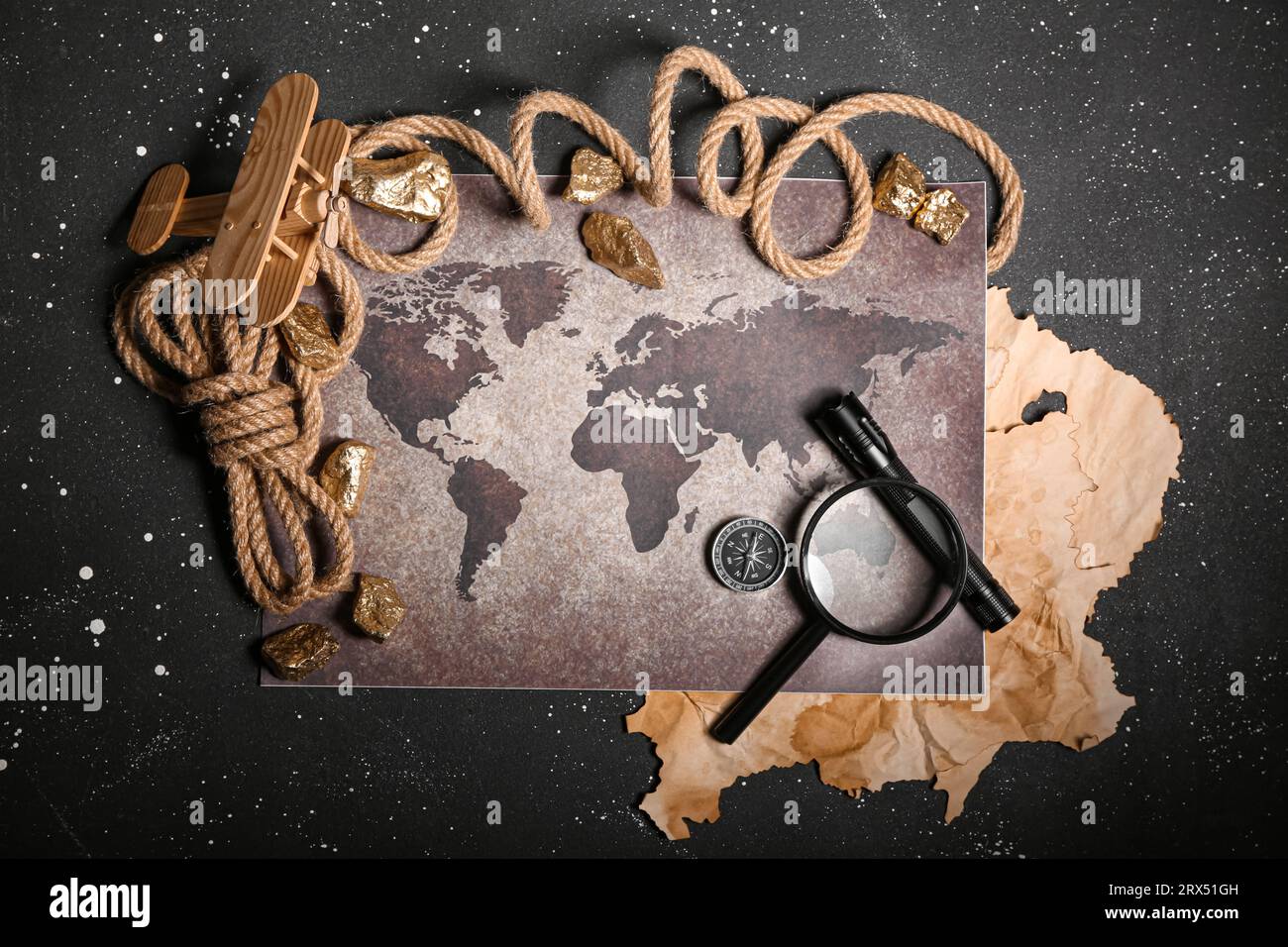 World map with travel equipment, airplane toy and golden nuggets on ...