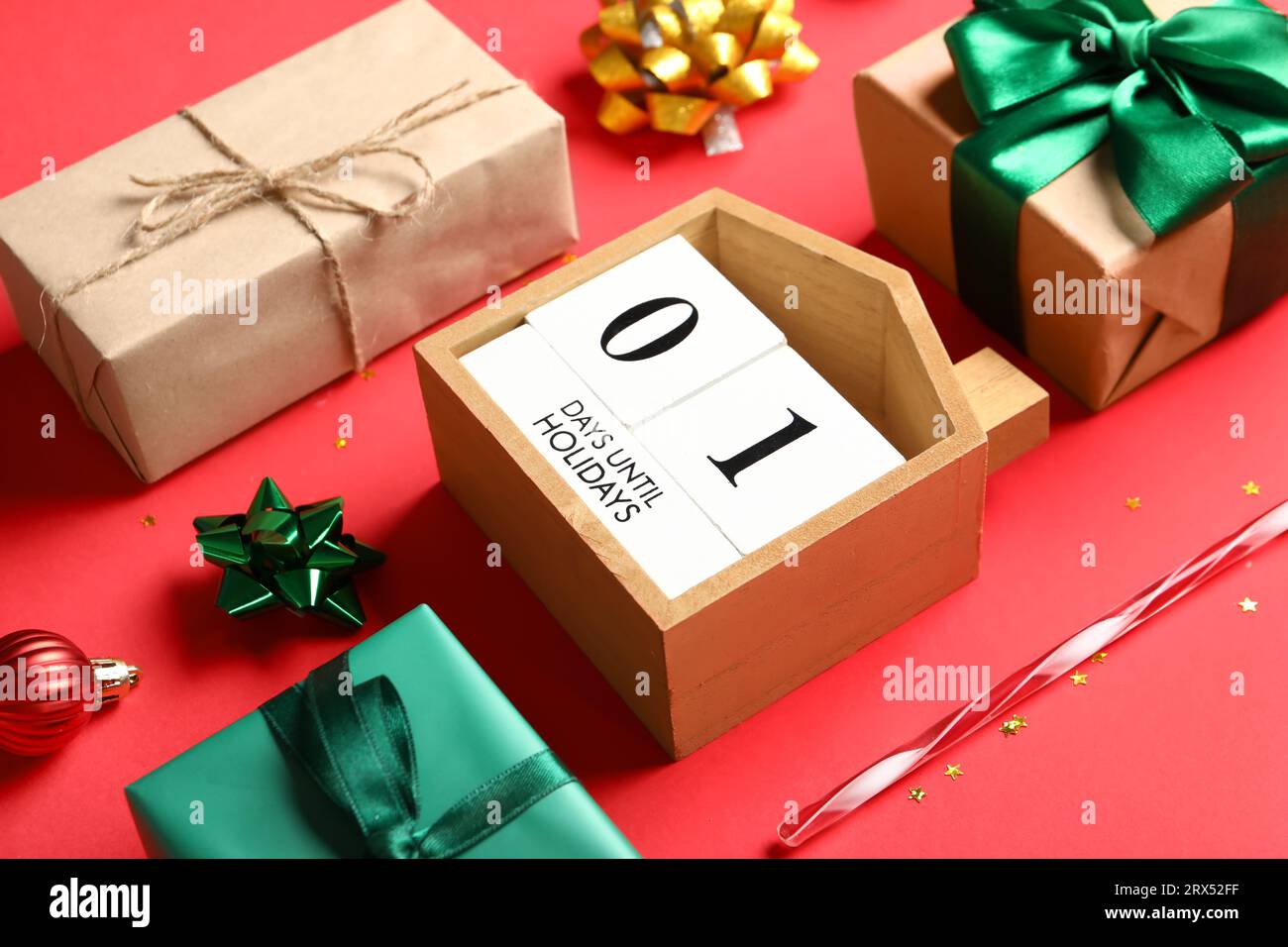 Countdown calendar with Christmas decorations and gift boxes on red ...