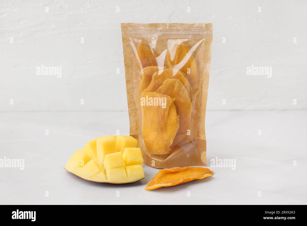 Package with slices of dried mango on white background Stock Photo - Alamy