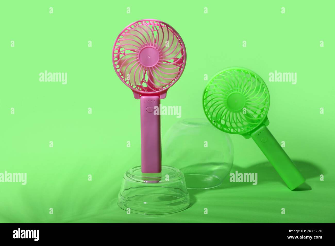 Portable electric fans on green background Stock Photo - Alamy